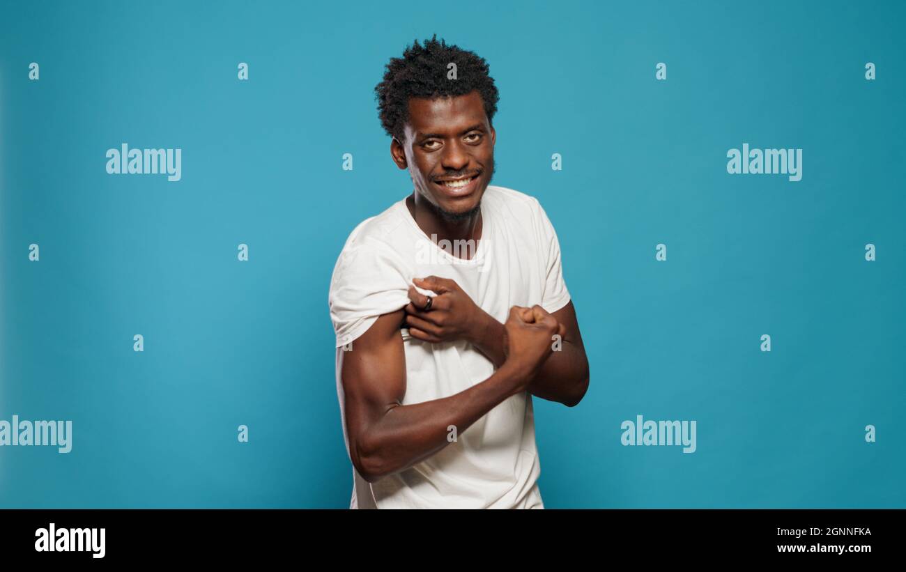 Sporty adult pointing at musculature and talking about training. Strong ...