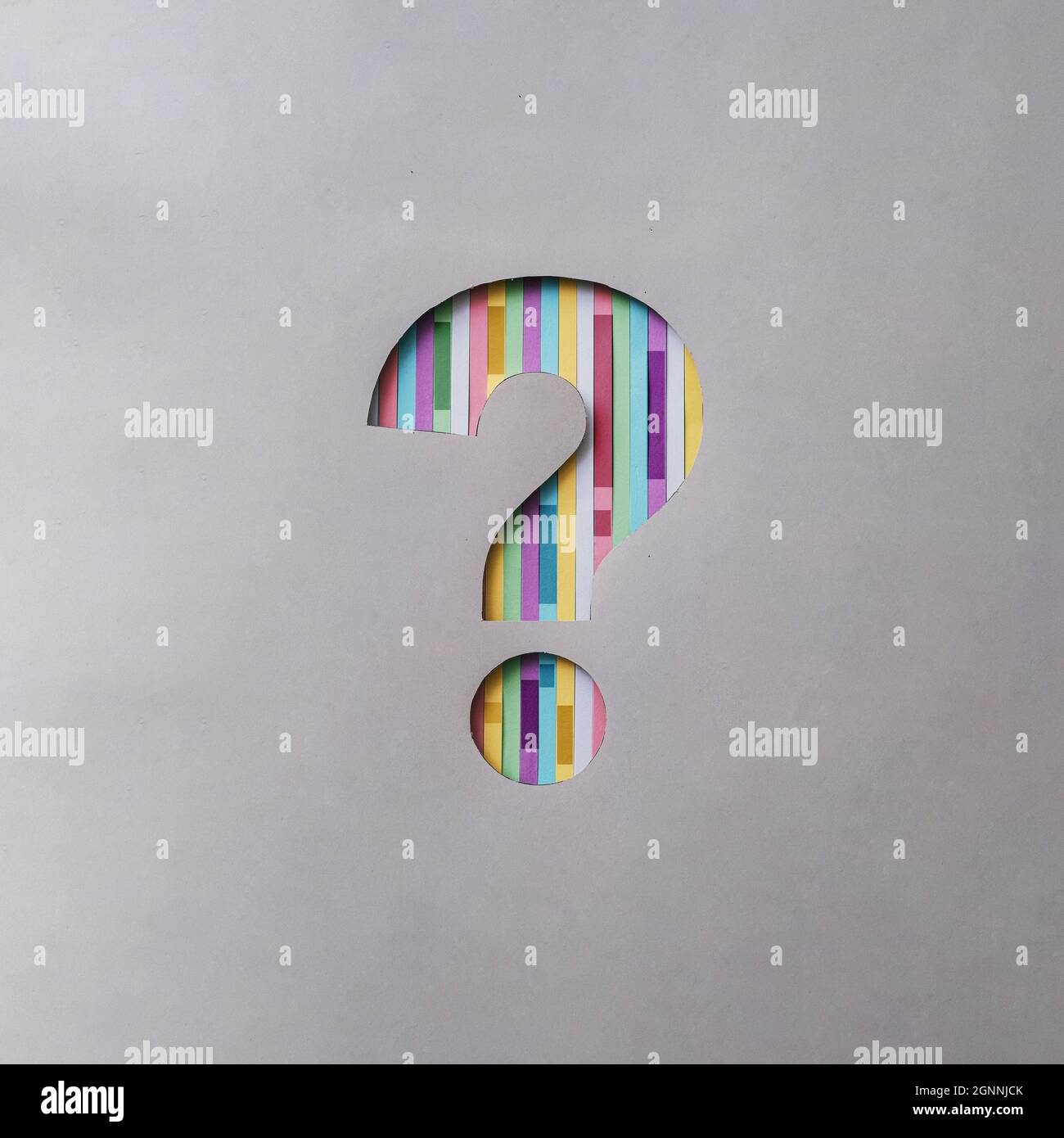 Creative symbol question mark cut out in a gray background with colored ...