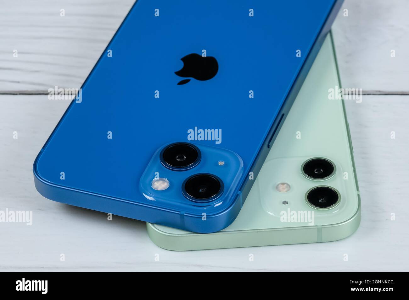 iPhone 13 in blue and iPhone 12 in green Stock Photo - Alamy