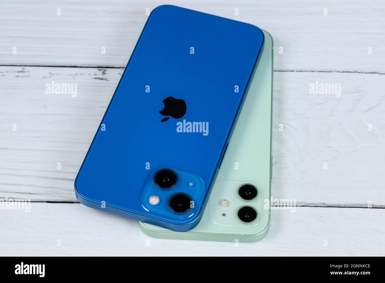 iPhone 13 in blue and iPhone 12 in green Stock Photo - Alamy