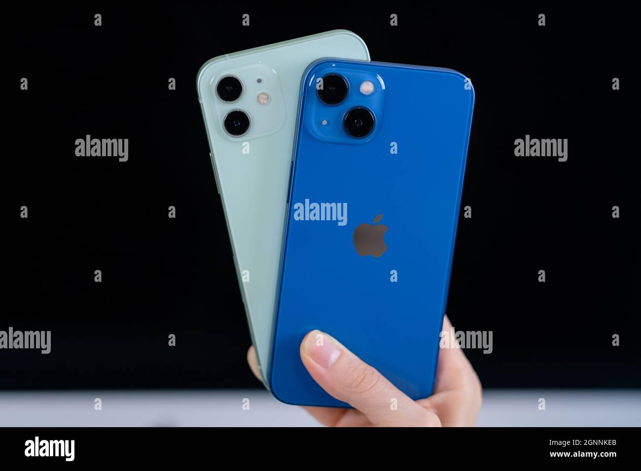 iPhone 13 in blue and iPhone 12 in green Stock Photo - Alamy
