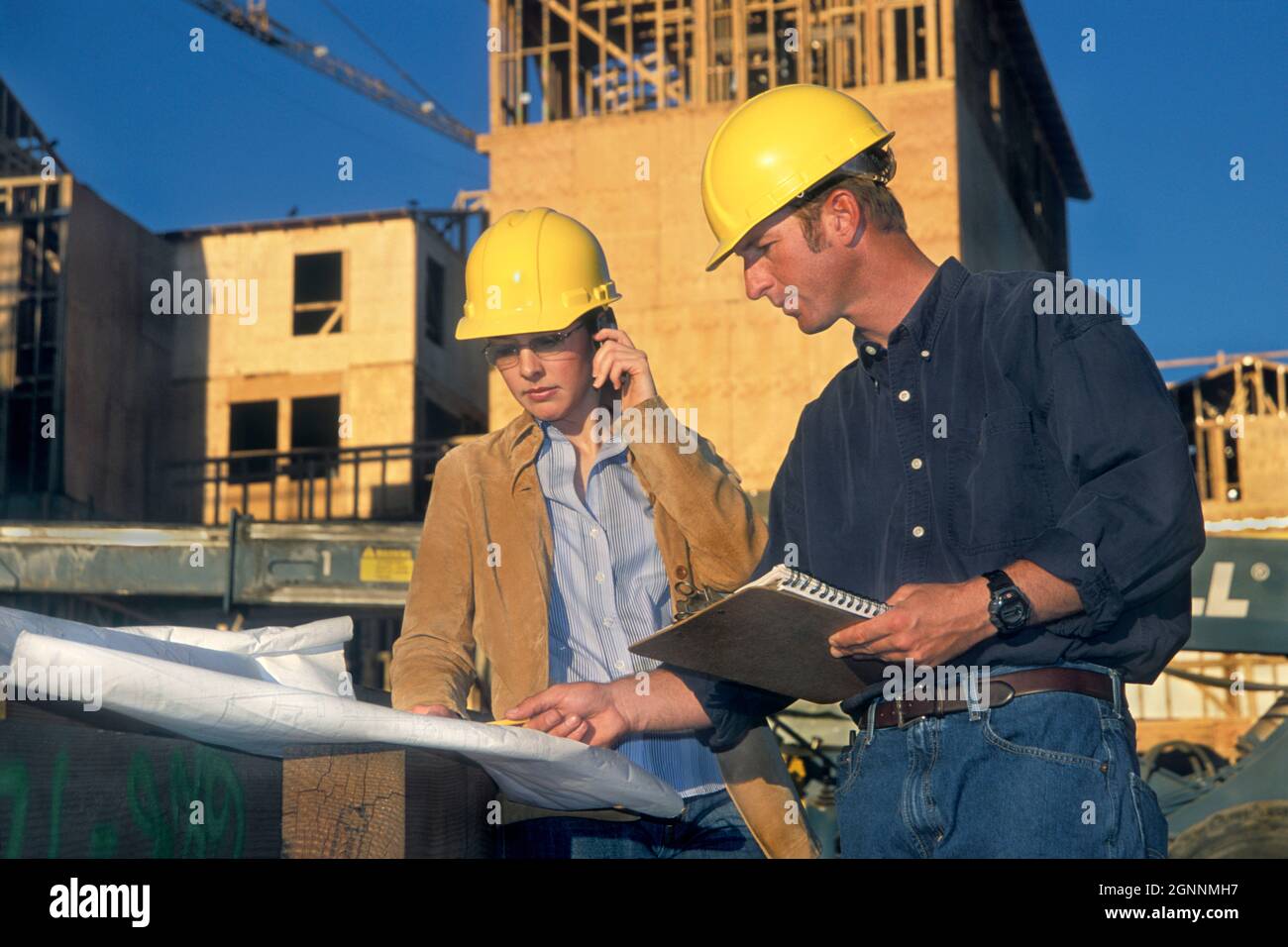 Architect and contractor discuss plan at construction site5, Los ...