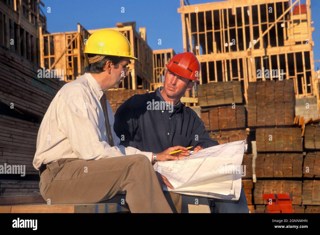Architect and contractor discuss plan at construction site12, Los ...