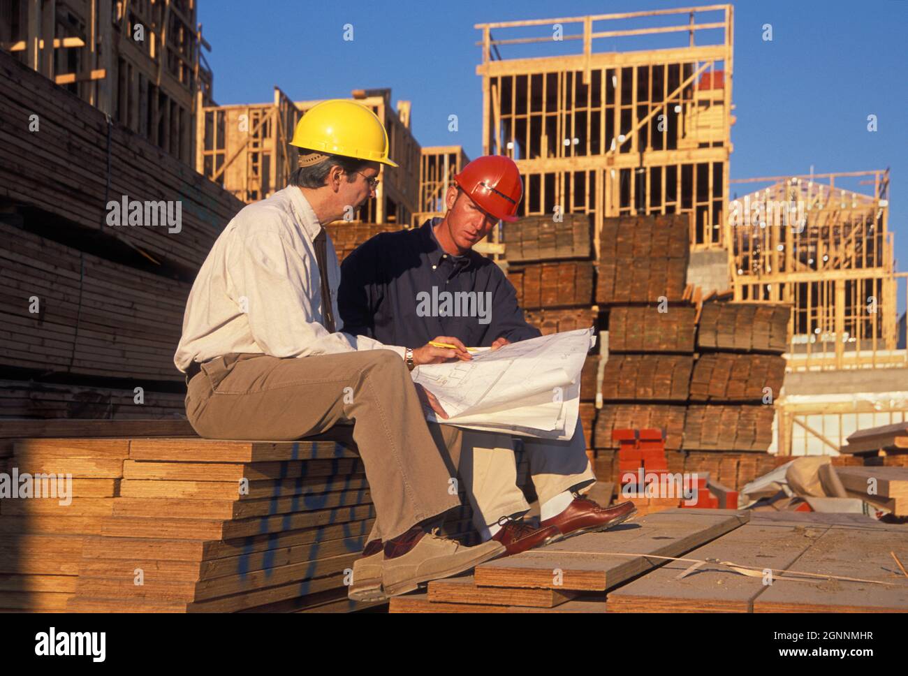 Architect and contractor discuss plan at construction site13, Los ...