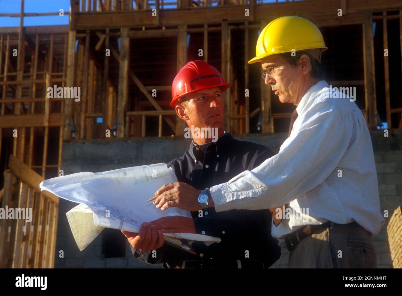 Architect and contractor discuss plan at construction site14, Los ...