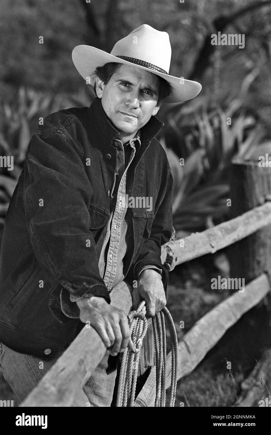 A cowboy leaning on a fence with a lariat in Los Angeles, California MR ...