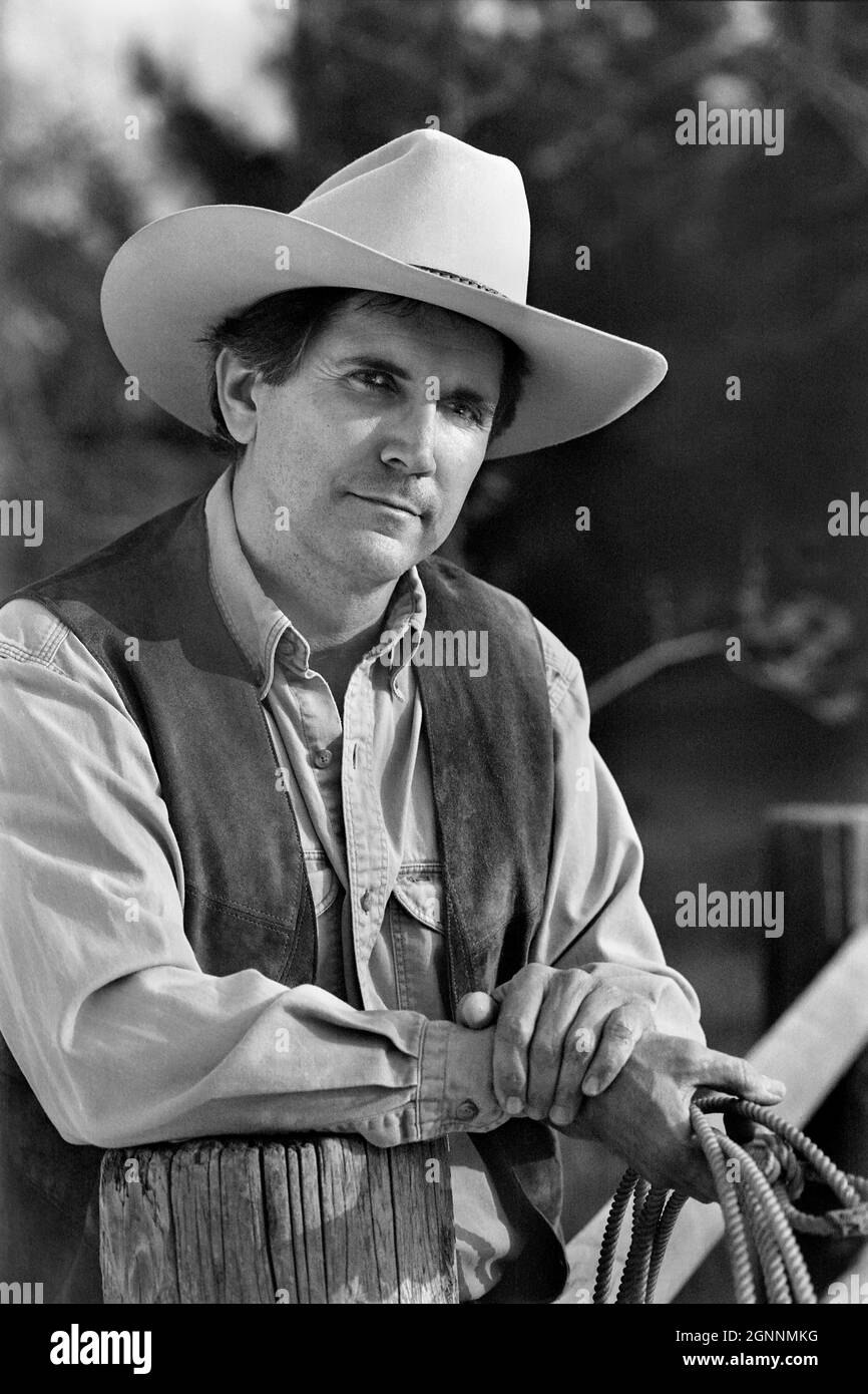 Cowboy leaning on fence Black and White Stock Photos & Images - Alamy