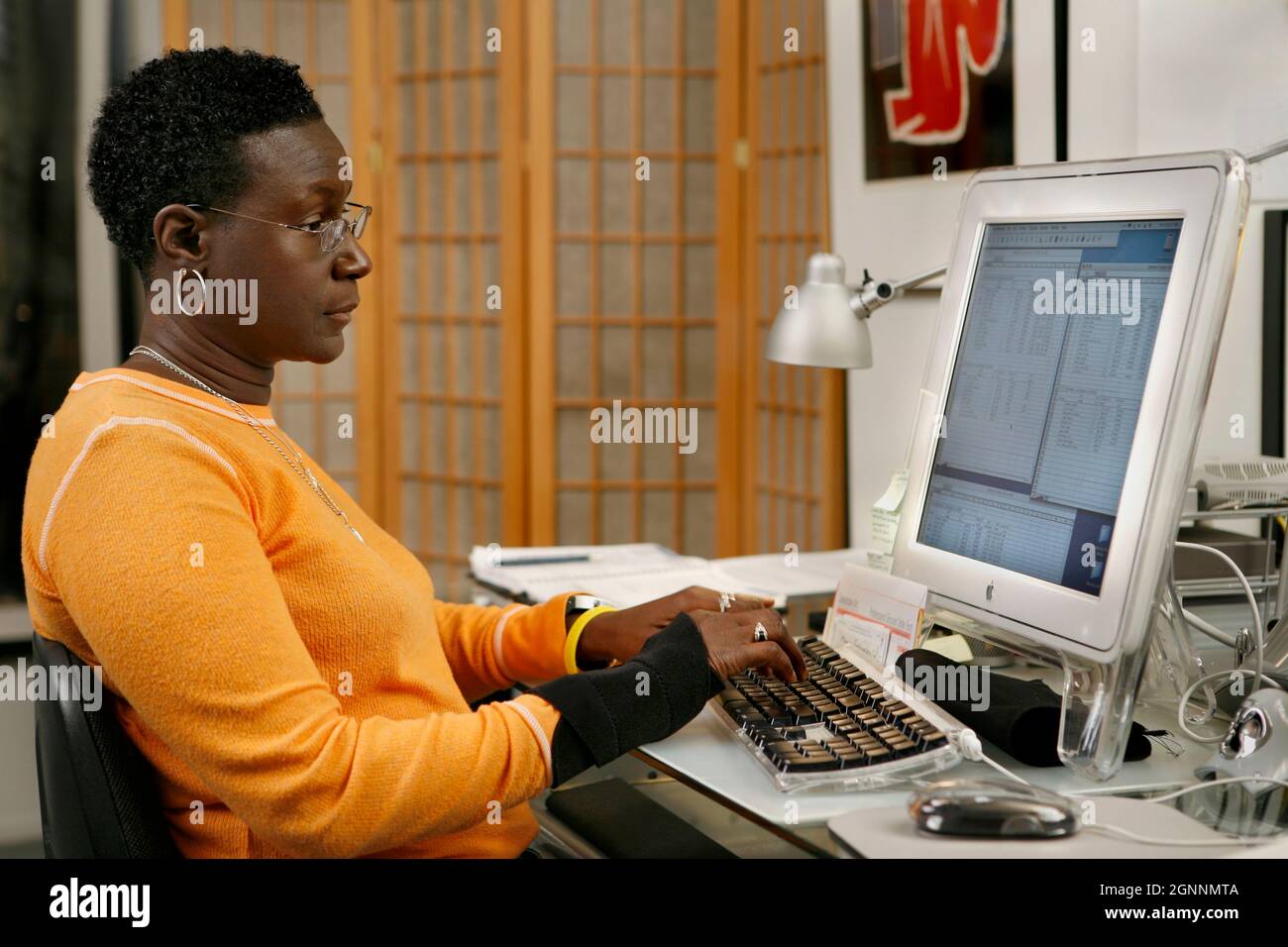 Woman with a wrist brace working on the computer MR - Model released ...