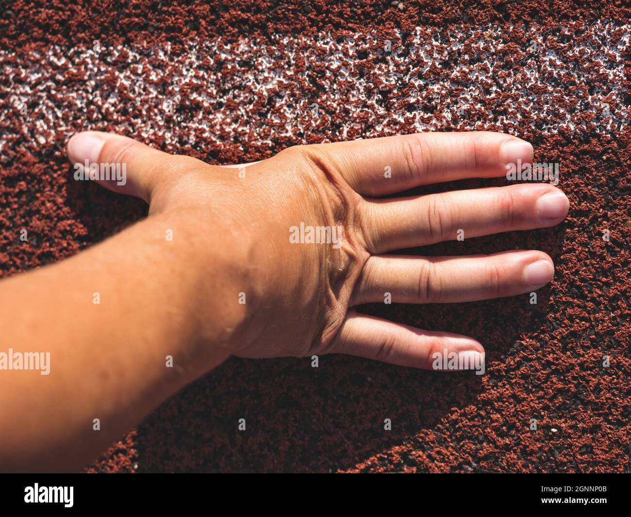 Female wrist with outstretched fingers at the starting line of a ...