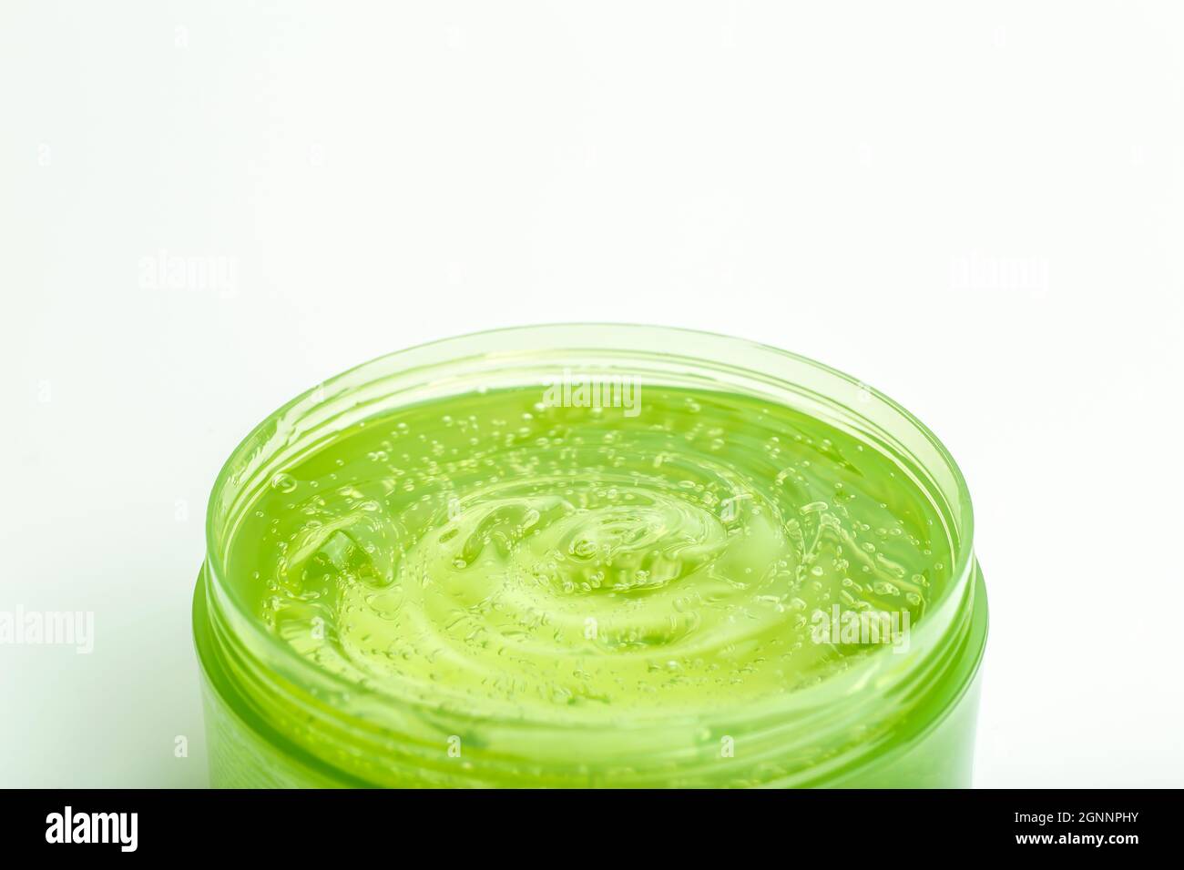Cosmetic gel in a jar on a white background. Green transparent gel with ...
