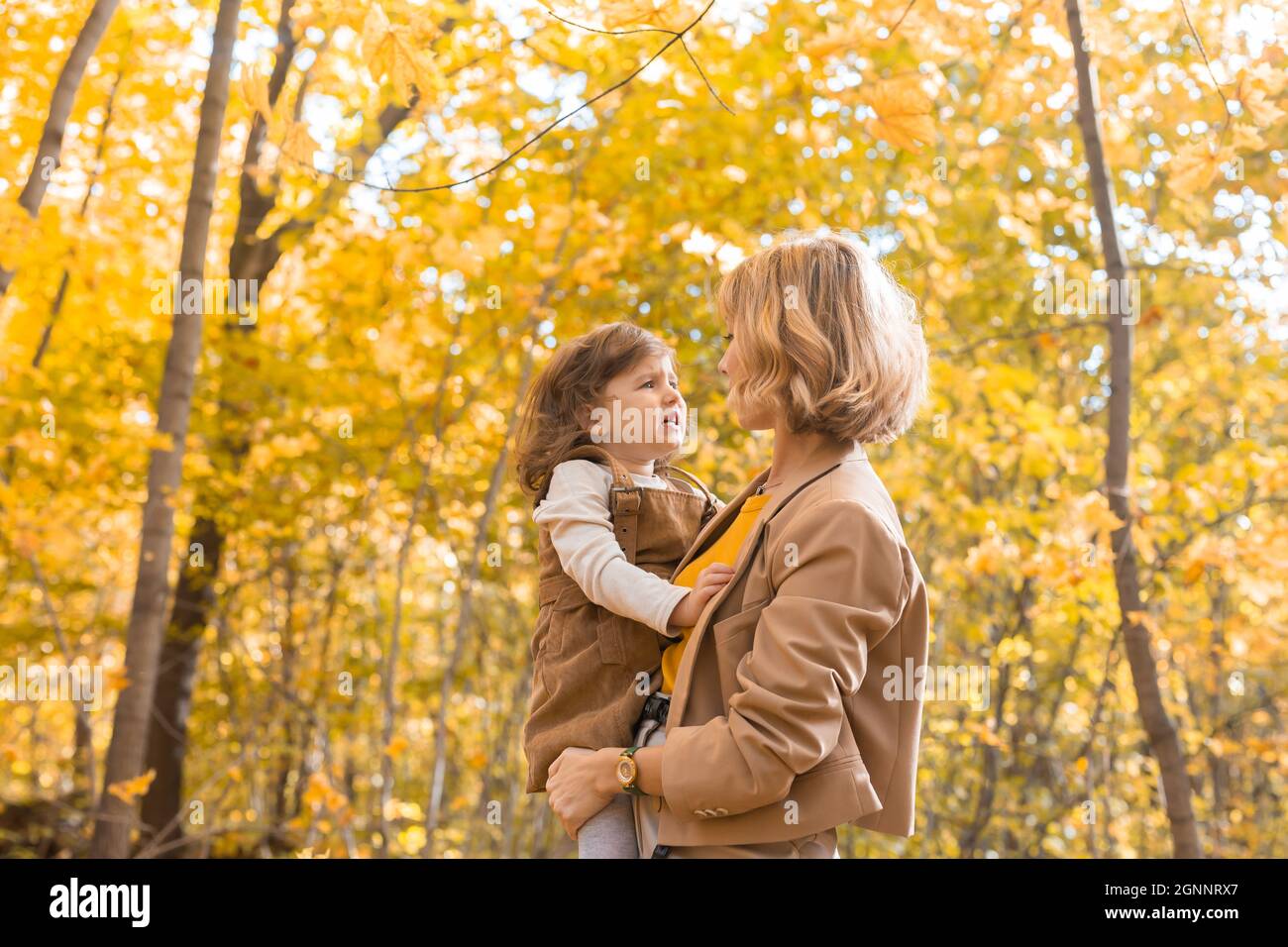 Young mother with her little daughter in an autumn park. Fall season ...