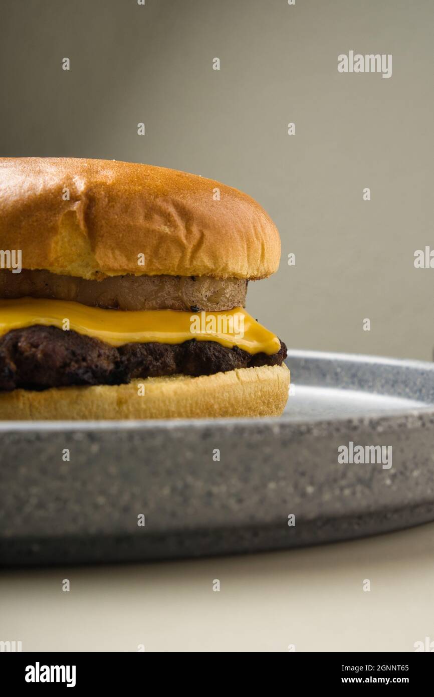 Vertical shot of a delicious cheeseburger on a gray plate Stock Photo ...