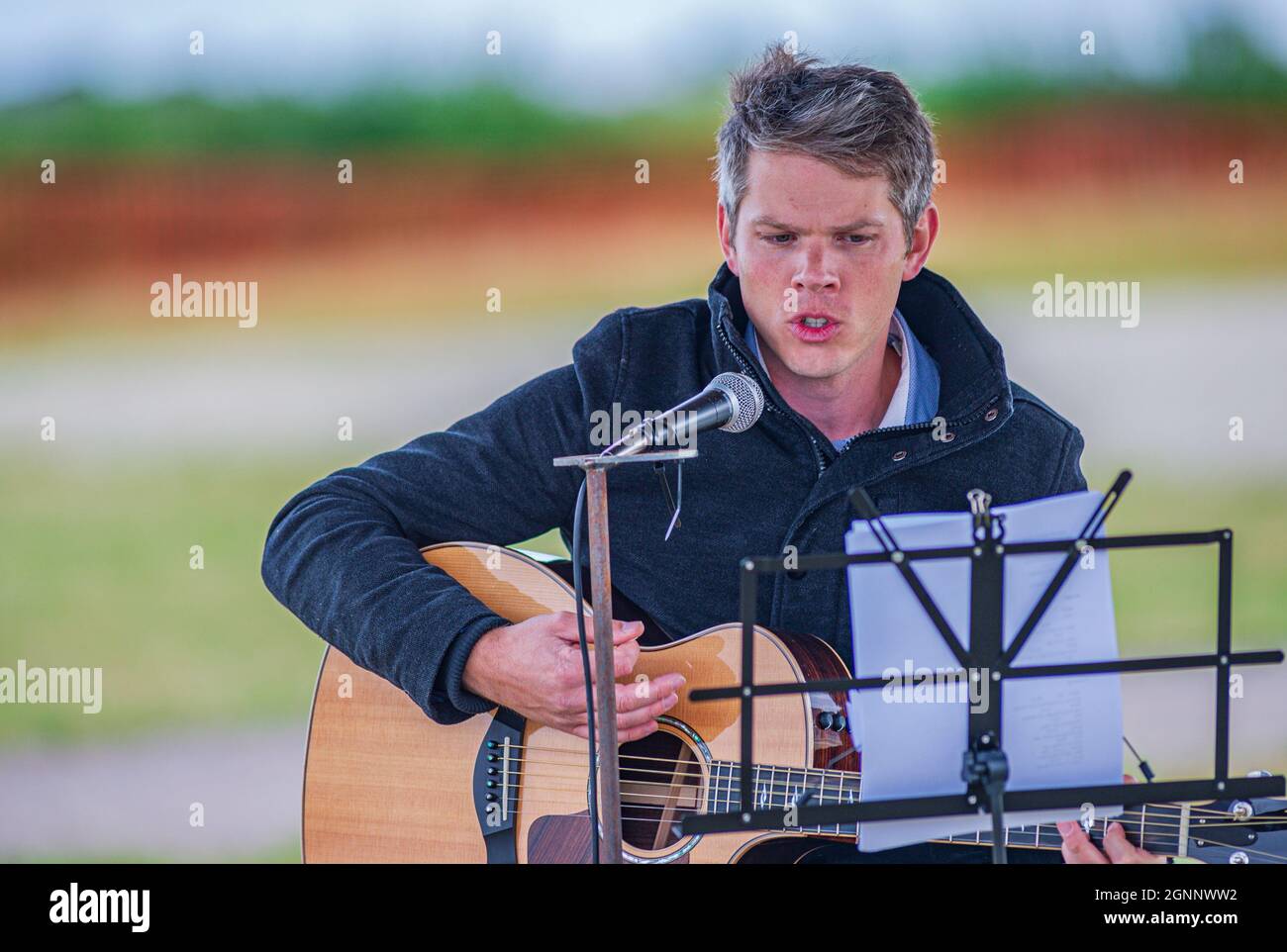 A guitarist and folk singer performing at an outdoor event Stock Photo ...