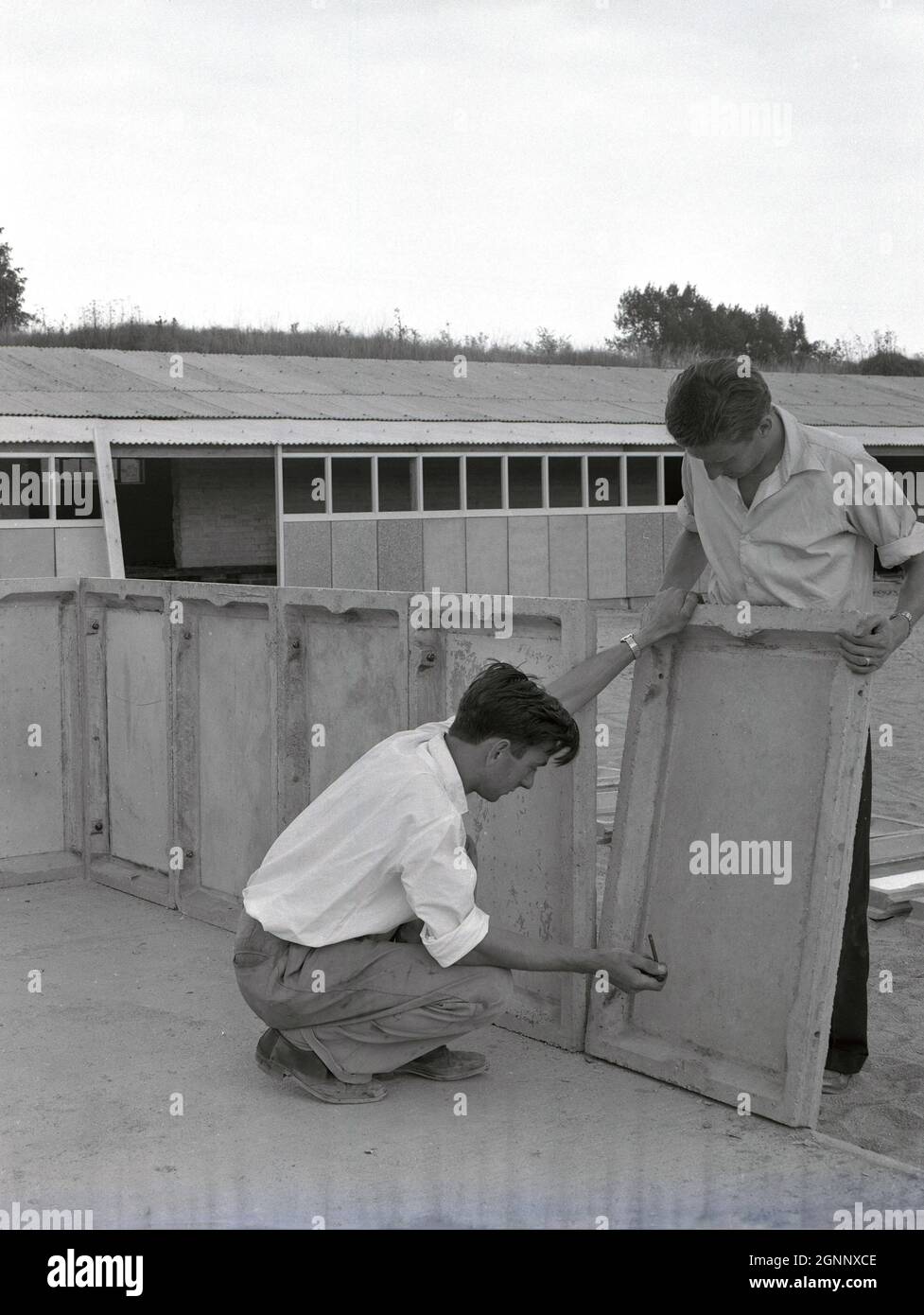 1960s, historical, constructing a prefab garage on an industrial ...