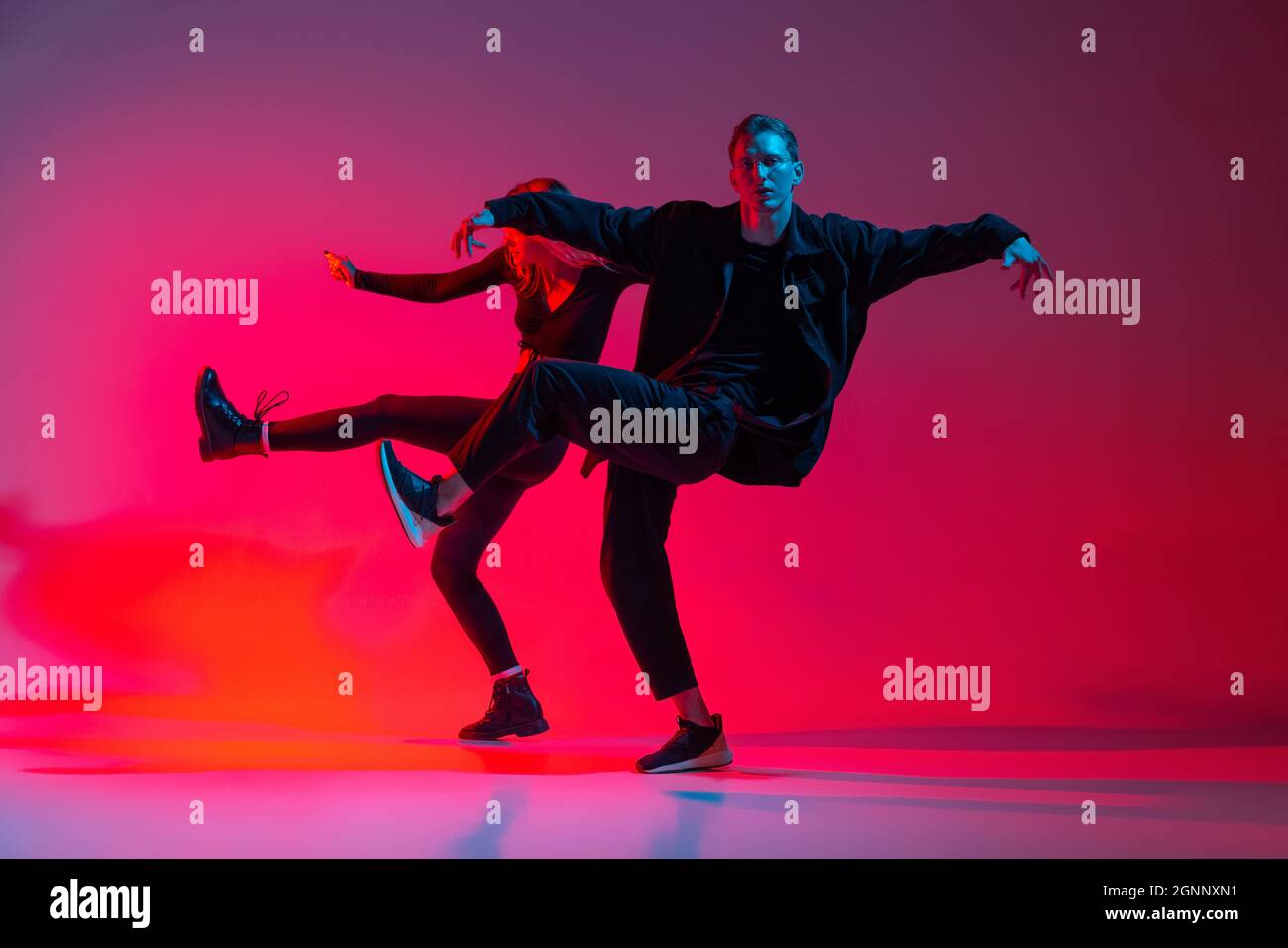 Horizontal image of young couple dancing hip-hop isolated over gradient ...