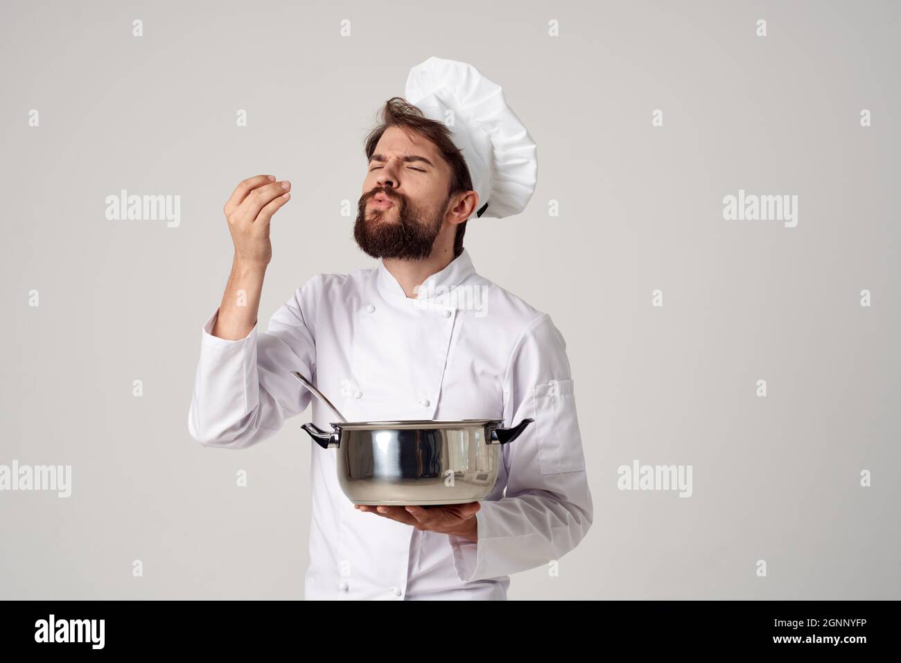 professional chef with a saucepan in his hands trying food cooking work ...
