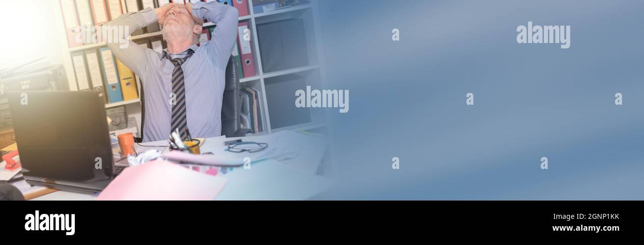 Overworked businessman sitting at a messy desk in office, light effect ...