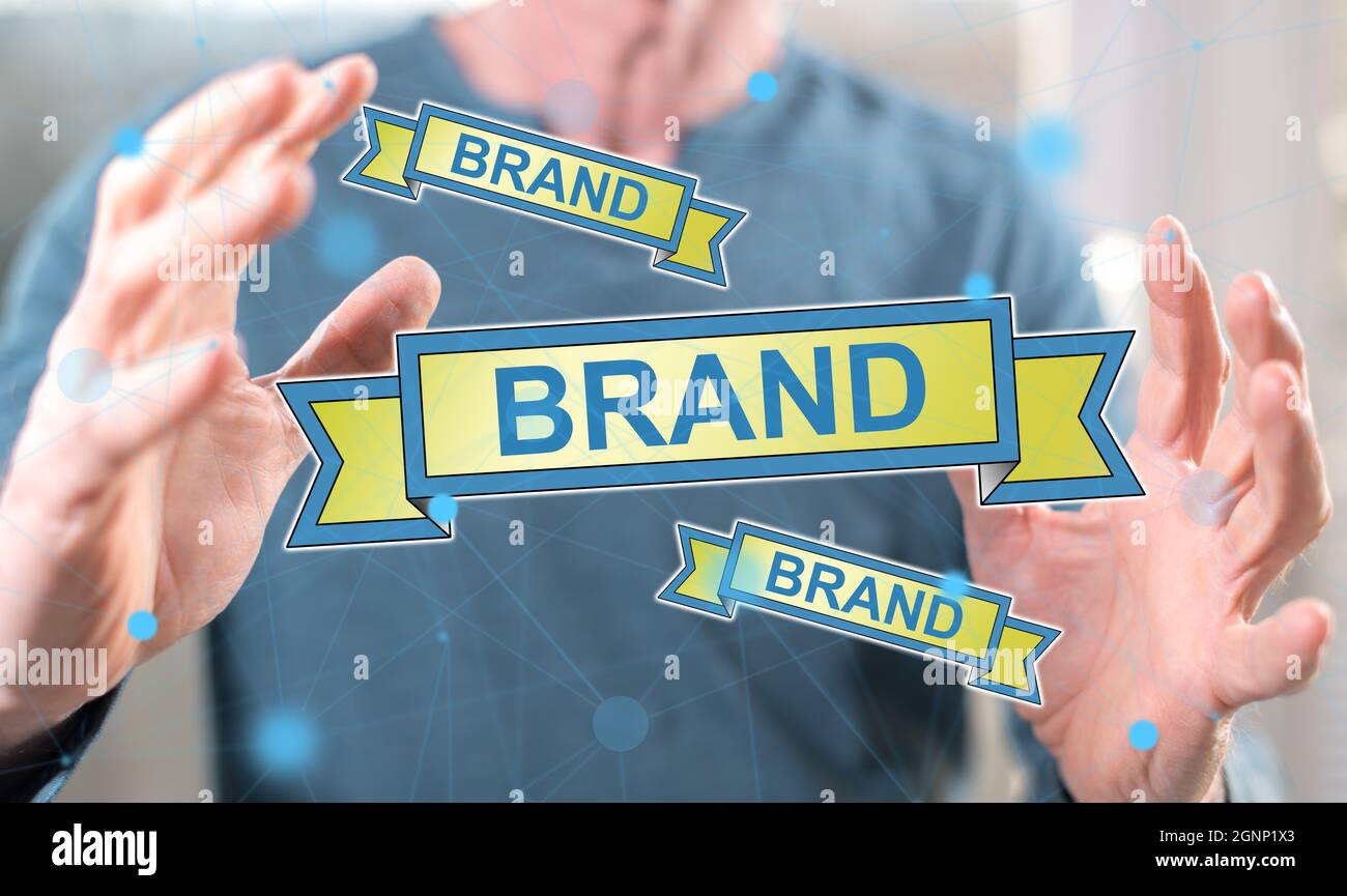 Brand concept between hands of a man in background Stock Photo - Alamy