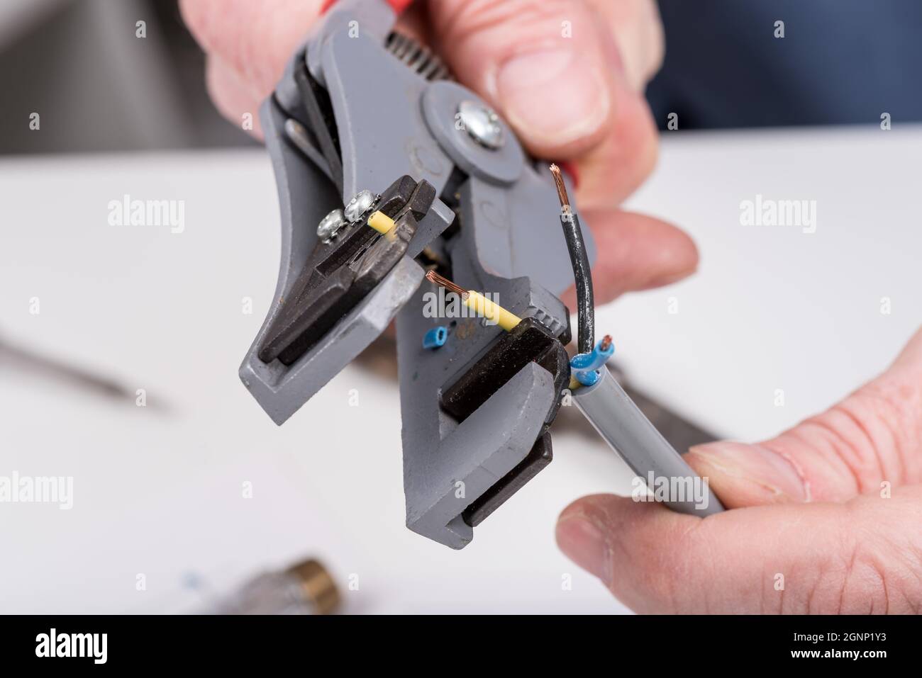 Action to strip a wire with a wire stripper, closeup Stock Photo - Alamy