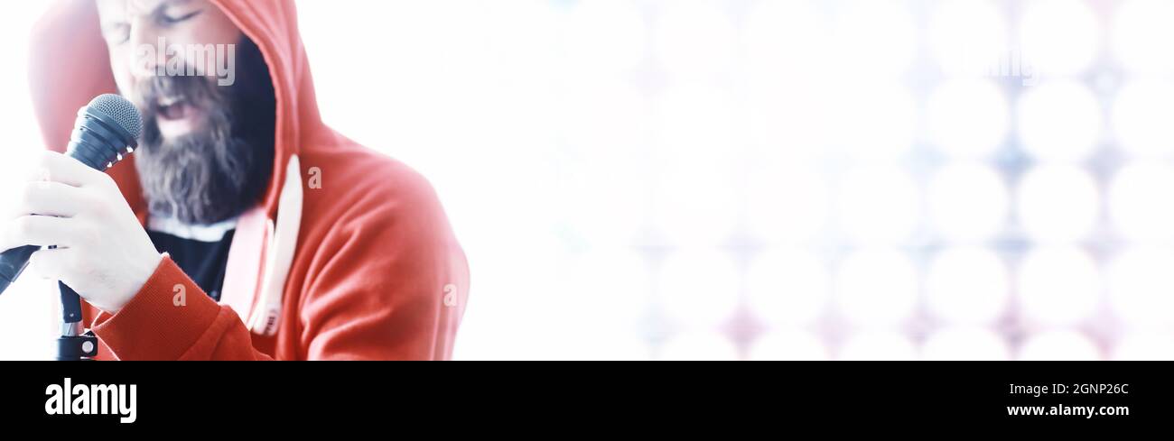 Stand with a microphone. Man holds hands a microphone on tripod ...