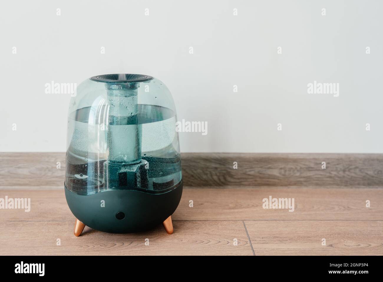 Modern air humidifier on a white wall background. Humidifier spreading ...