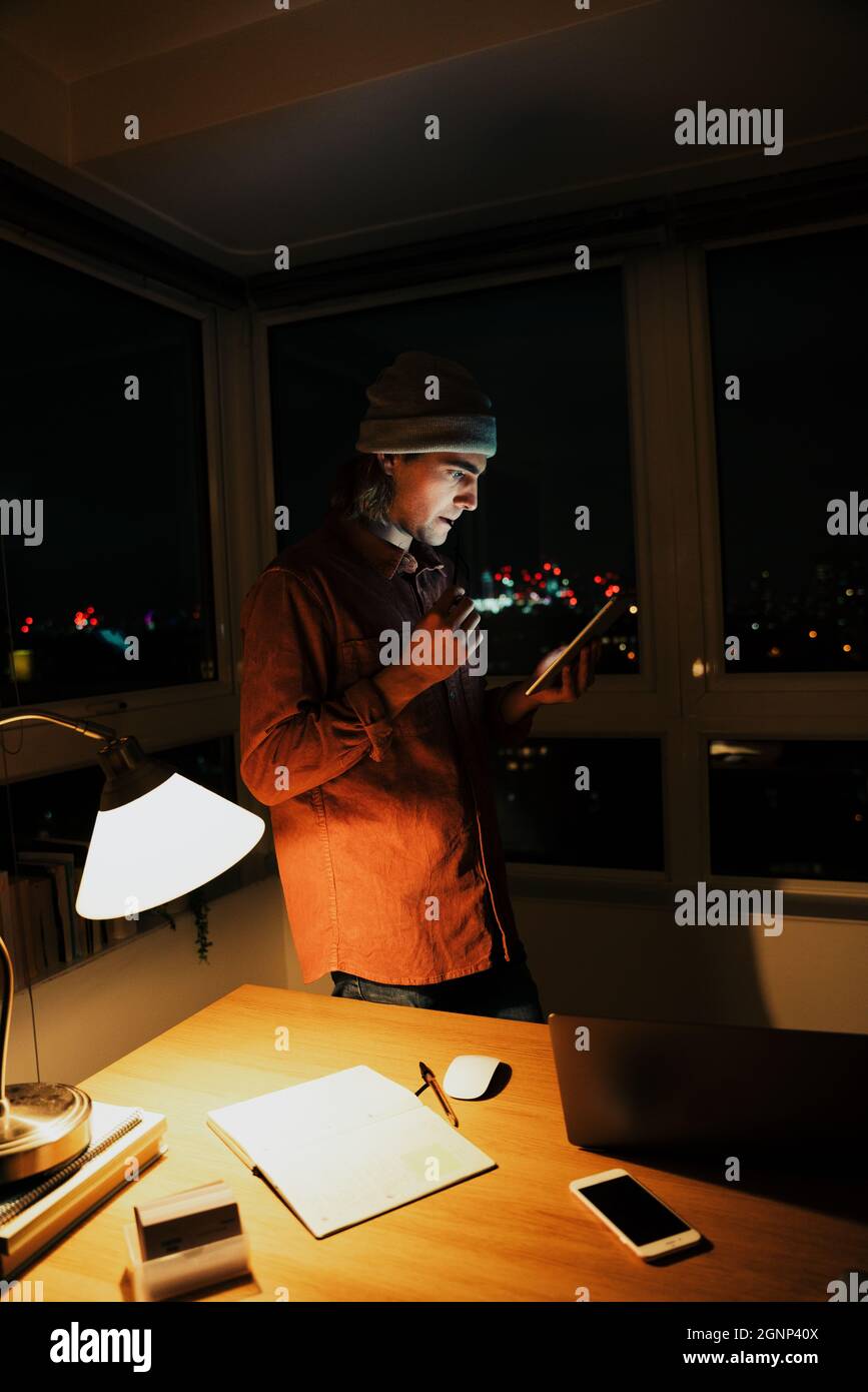 Young caucasian business man scrolling through emails on digital tablet ...