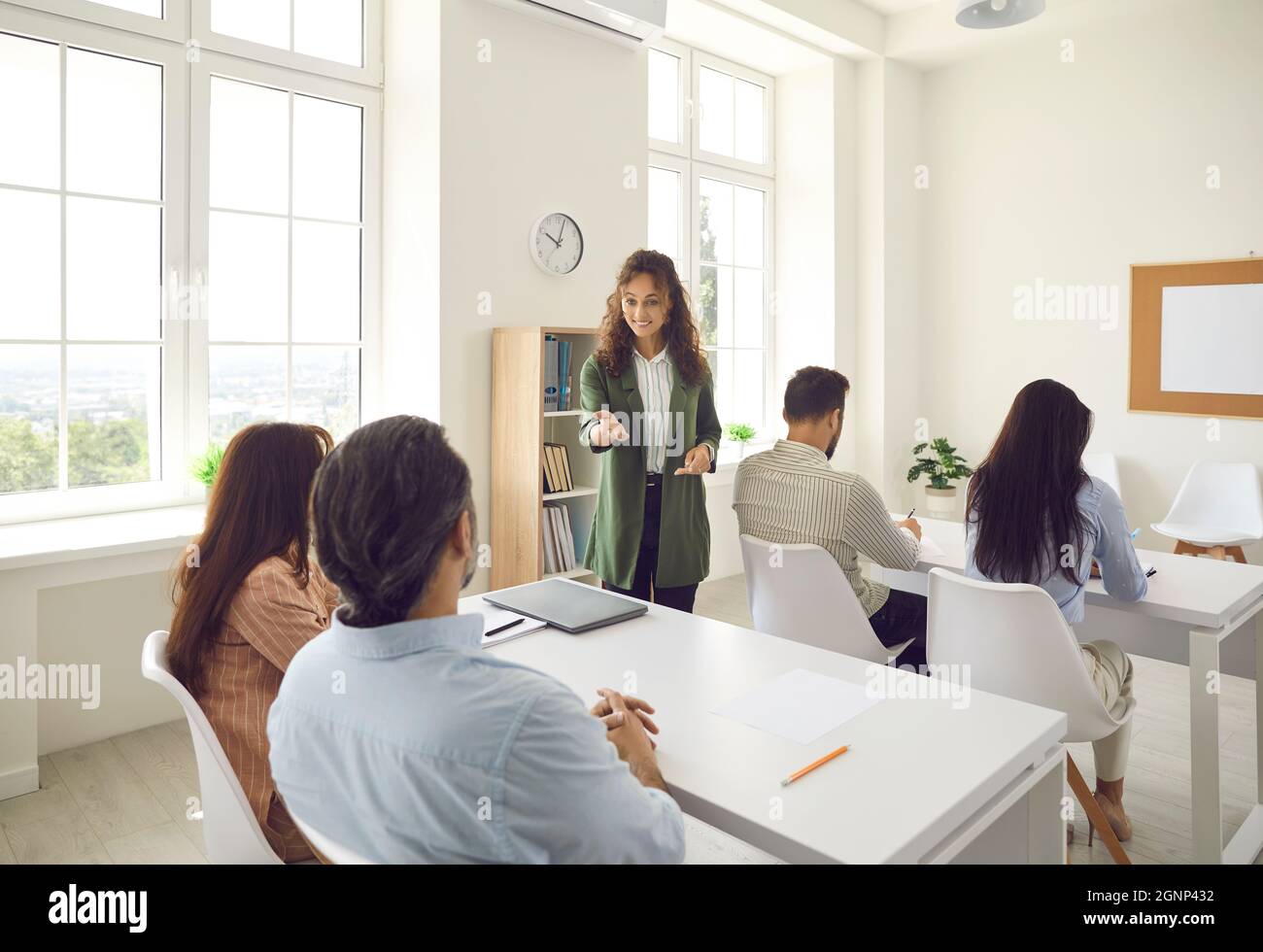 Female teacher communicates with a group of adult students at a seminar ...