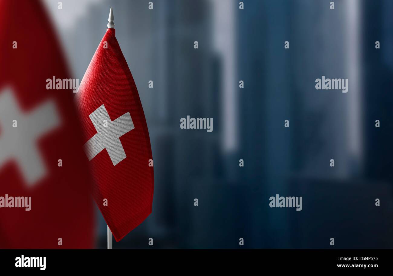 Small flags of Switzerland on a blurry background of the city Stock ...
