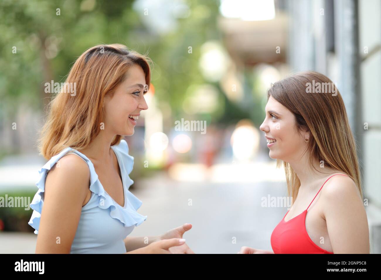 Profile of two happy friends talking and smiling in the street Stock ...
