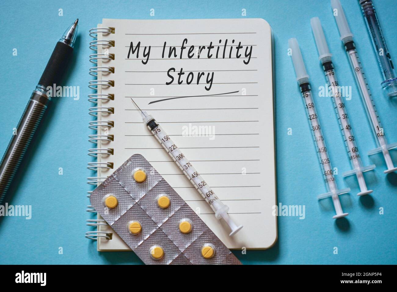 My infertility story text on white notepad with disposable injection ...