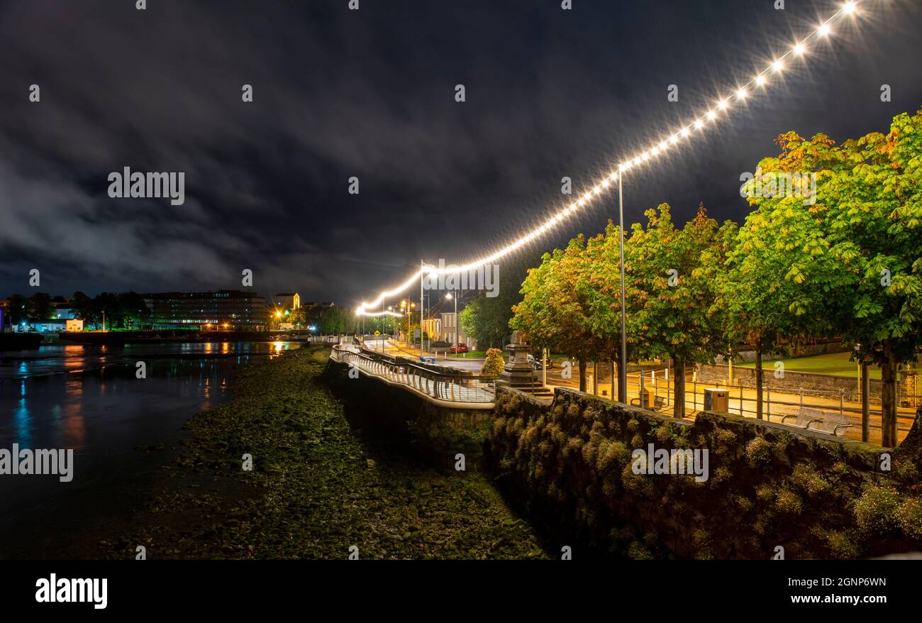 Limerick at night, illuminated walkway at the Shannon River ...