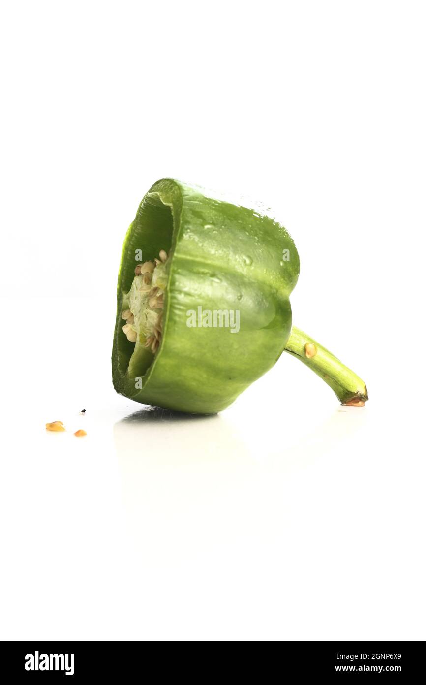 Closeup shot of half-cut green capsicum isolated on a white background ...