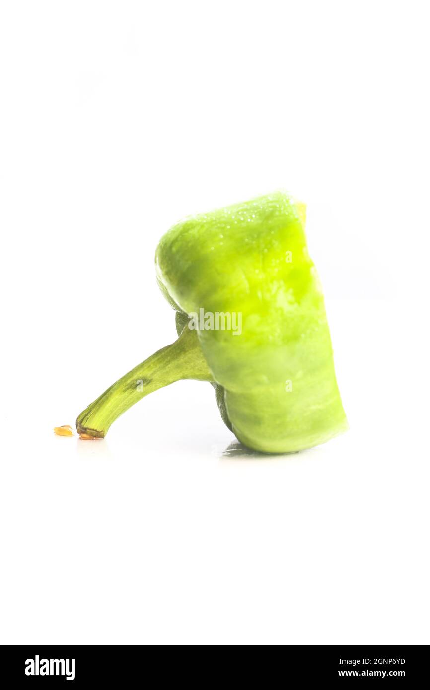 Closeup shot of half-cut green capsicum isolated on a white background ...