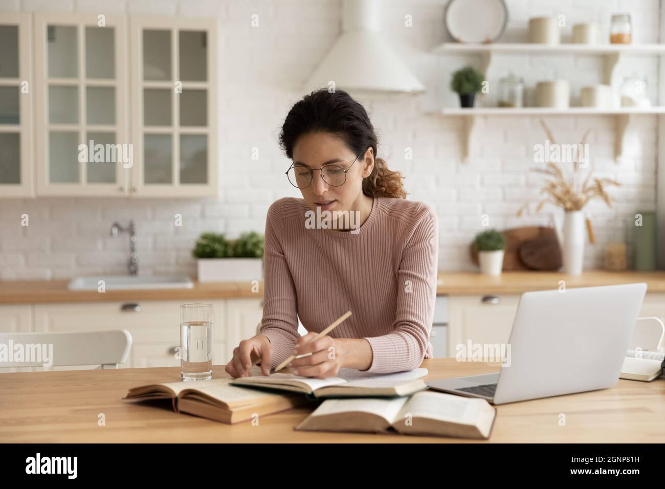 Millennial female study online with textbooks at home Stock Photo - Alamy