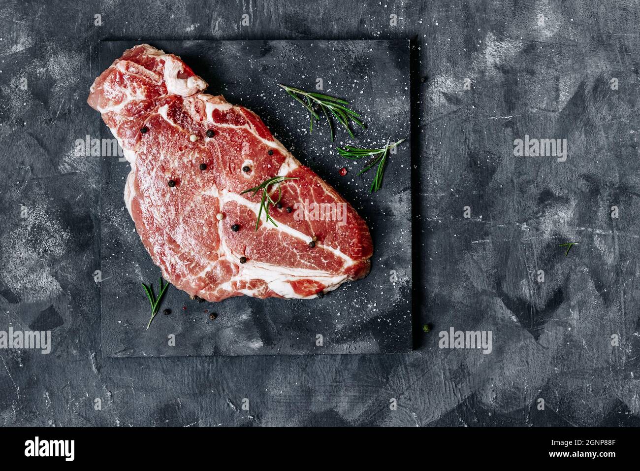 Raw marble pork steak on a dark board top view Stock Photo - Alamy
