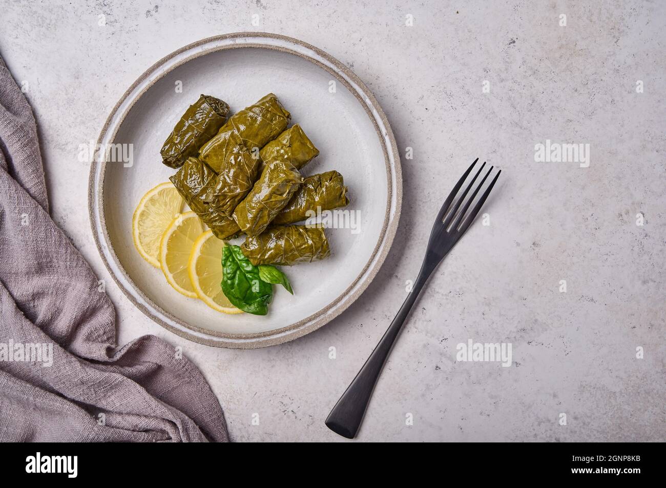 Dolma, stuffed grape leaves with rice and meat in light plate with ...