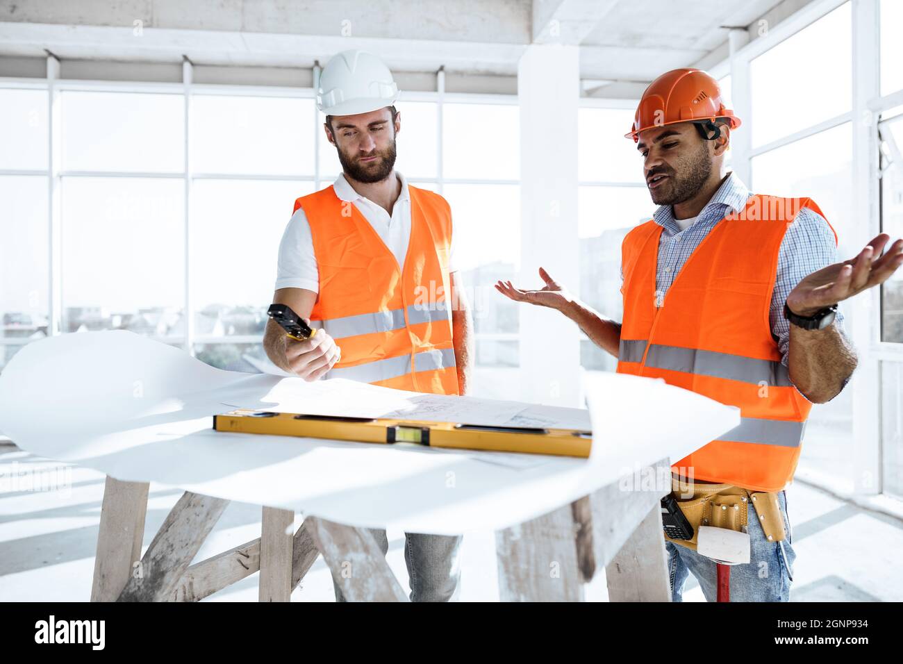 Two engineers man looking at project plan on the table in construction ...