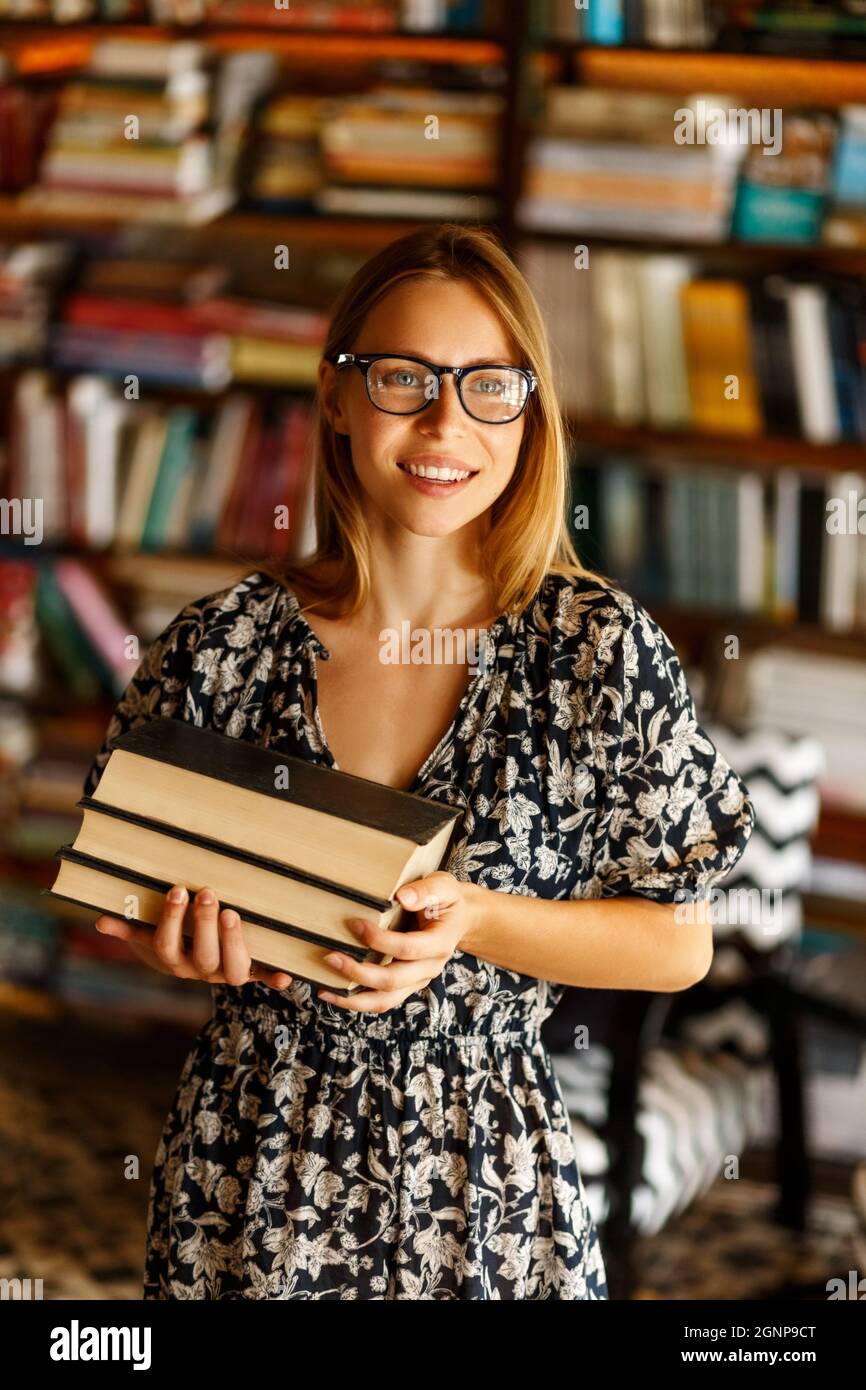 Back to school library concept. Student girl holding book on her hands ...