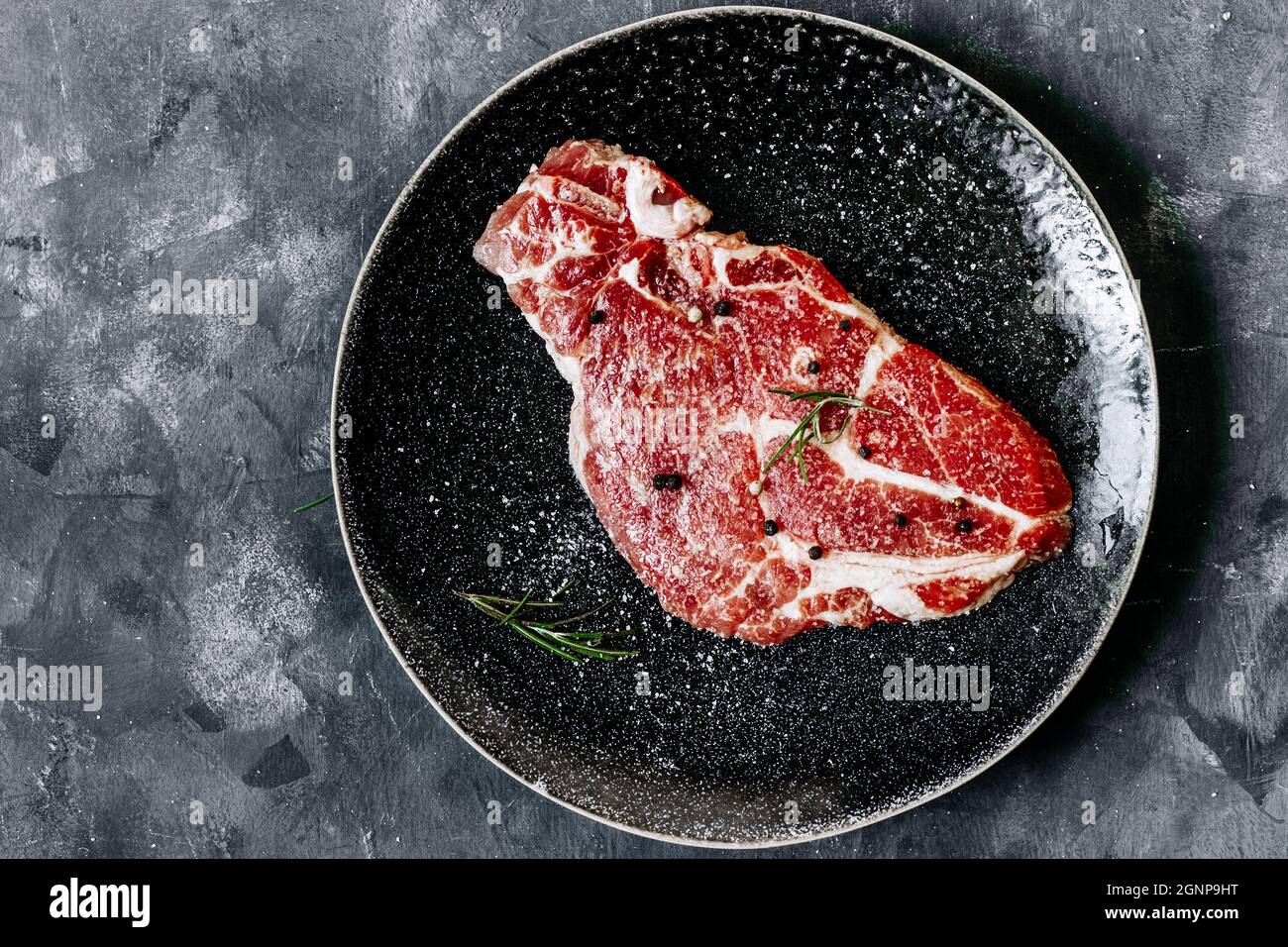 Raw marble pork steak on a dark plate top view Stock Photo - Alamy