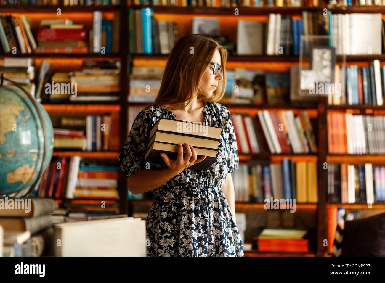Back to school library concept. Student girl holding book on her hands ...