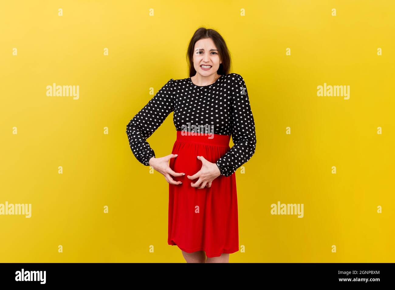 Pregnant woman scratching her belly on colored background Stock Photo ...