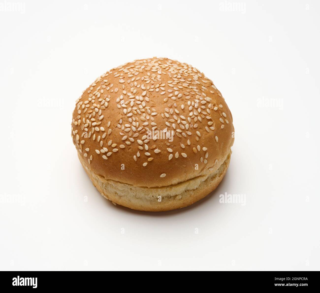 baked round fresh white wheat flour bun sprinkled with sesame seeds on ...