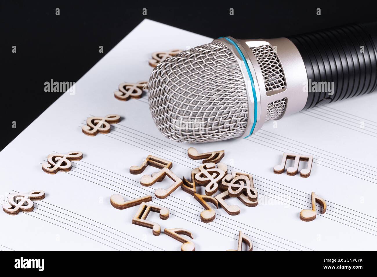 Microphone and wooden notes heaped on the stave Stock Photo - Alamy
