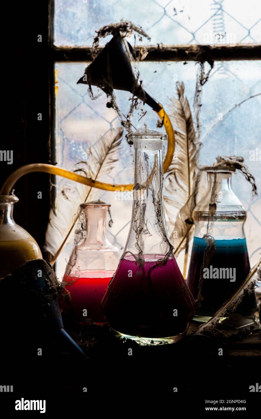 Magic potions in bottles near old rustic window with backlight ...