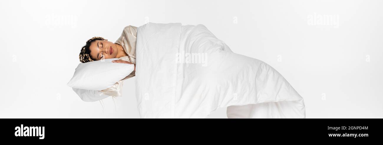 young african american woman sleeping on pillow under blanket while ...