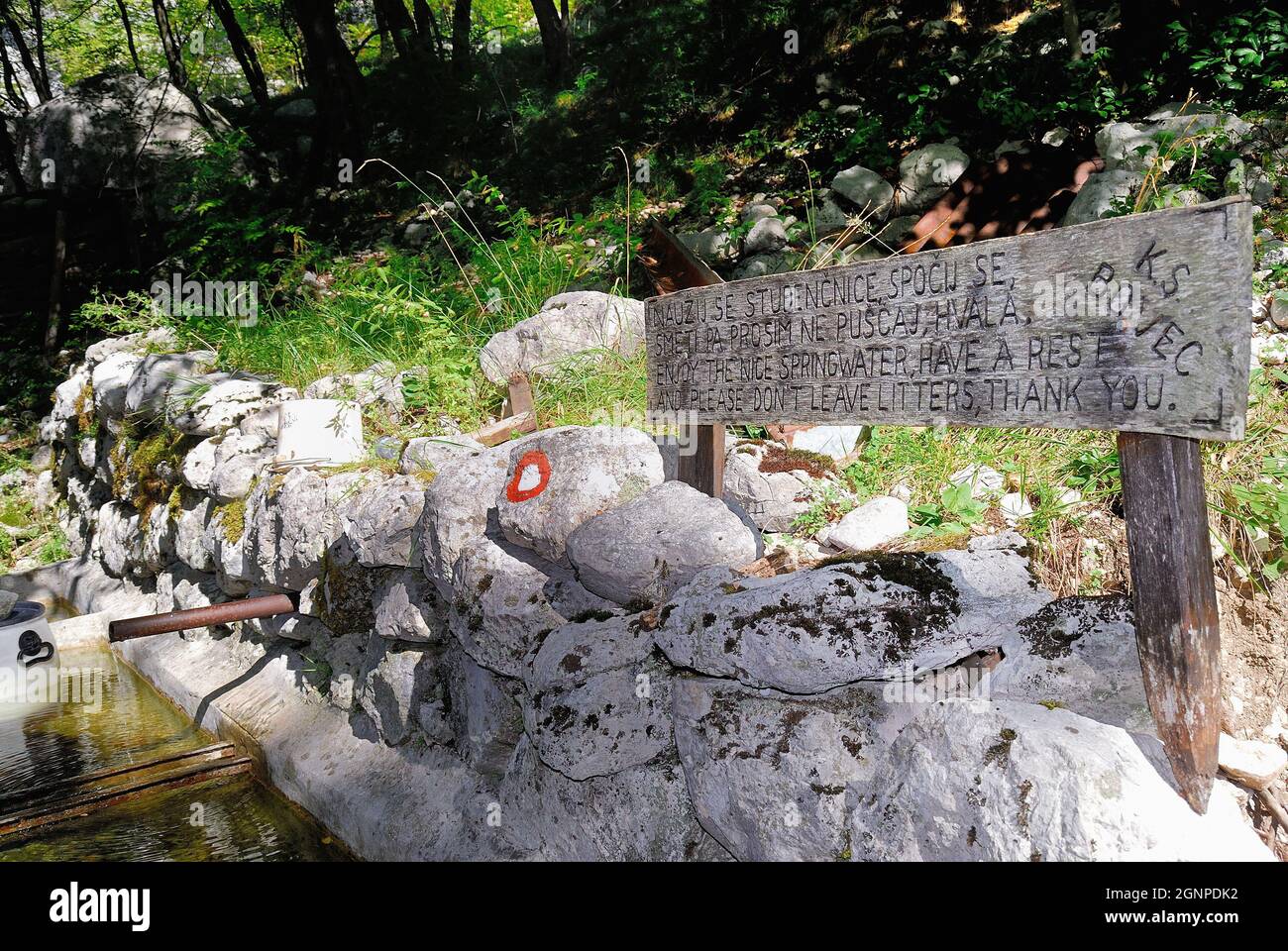 Slovenia, Bovec, the path for the mount Rombon. A fountain with ...