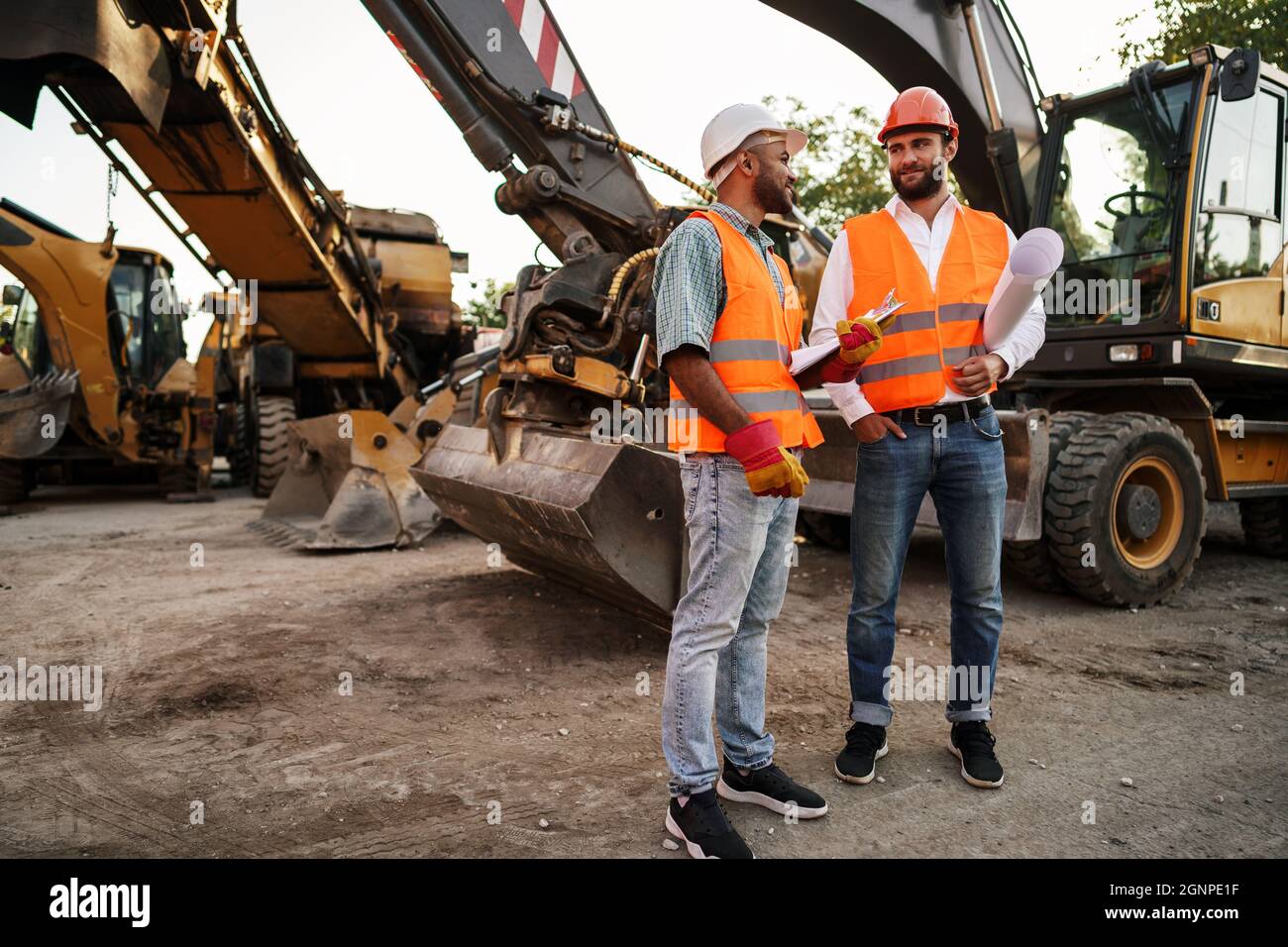 Two men engineers discussing their work standing against construction ...