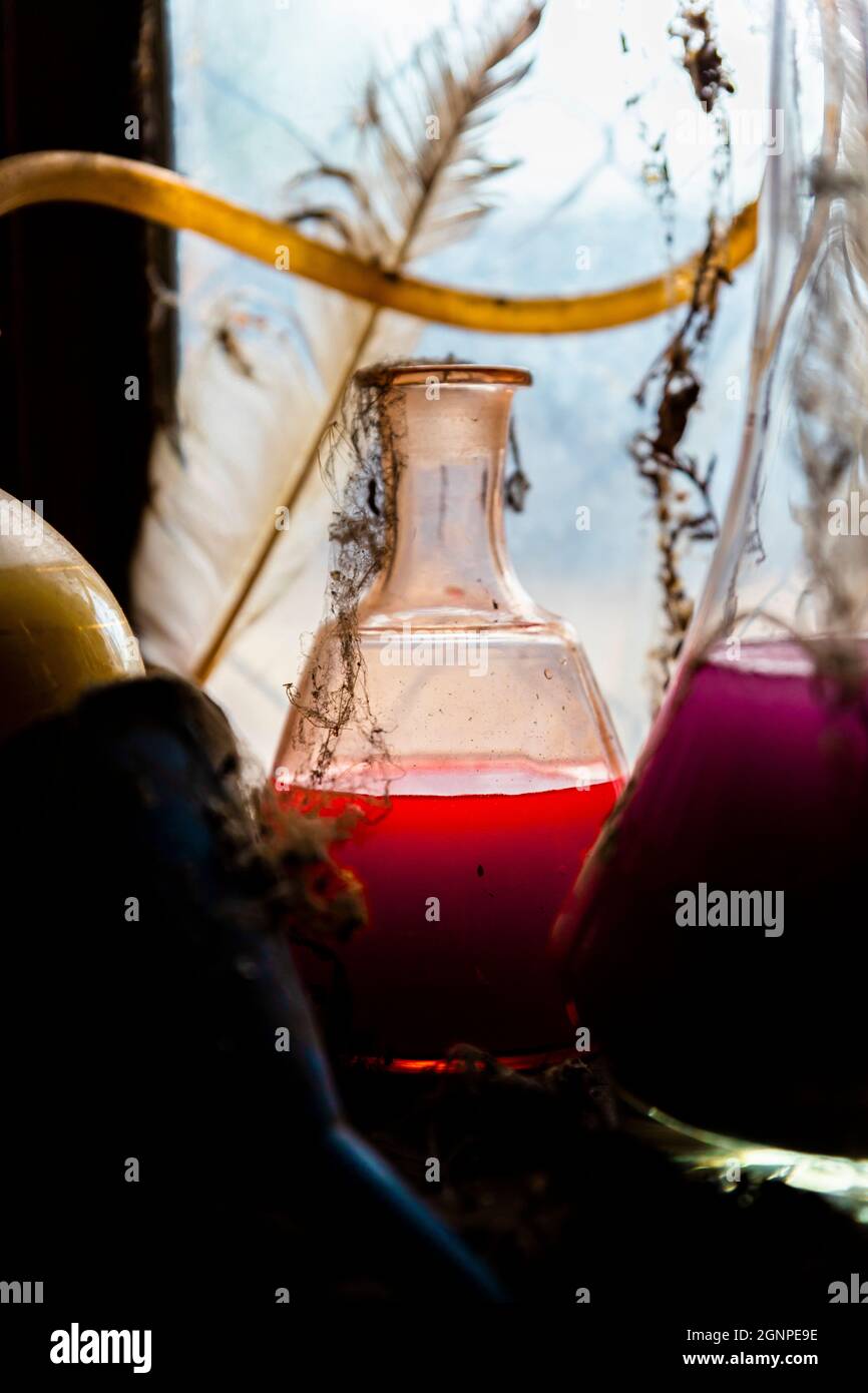 Magic potions in bottles near old rustic window with backlight ...