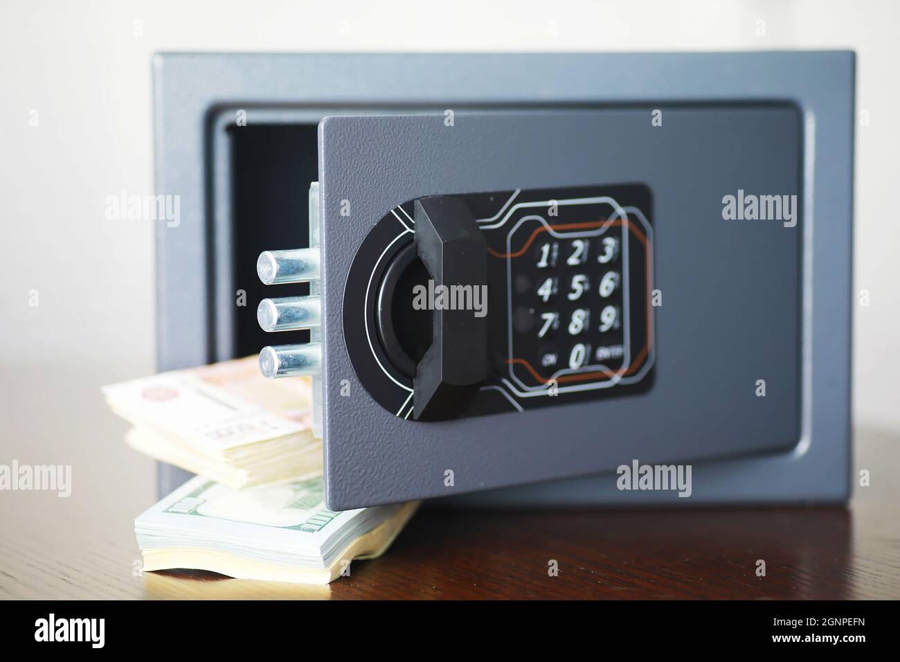 Steel safe with money. Hand putting password in the safety money box in ...
