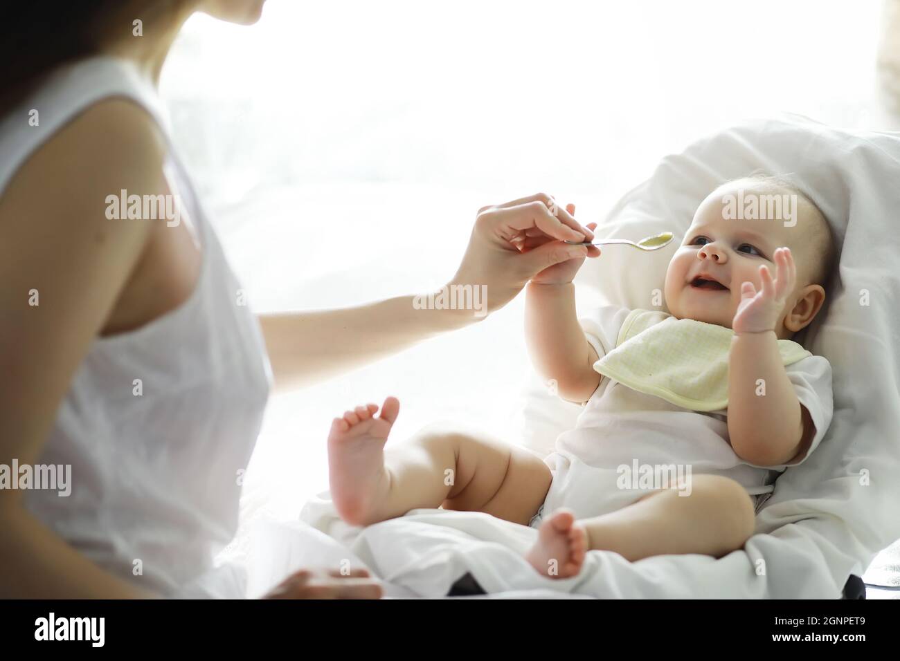 Maternity concept. A young mother feeds her little baby. First lure and ...